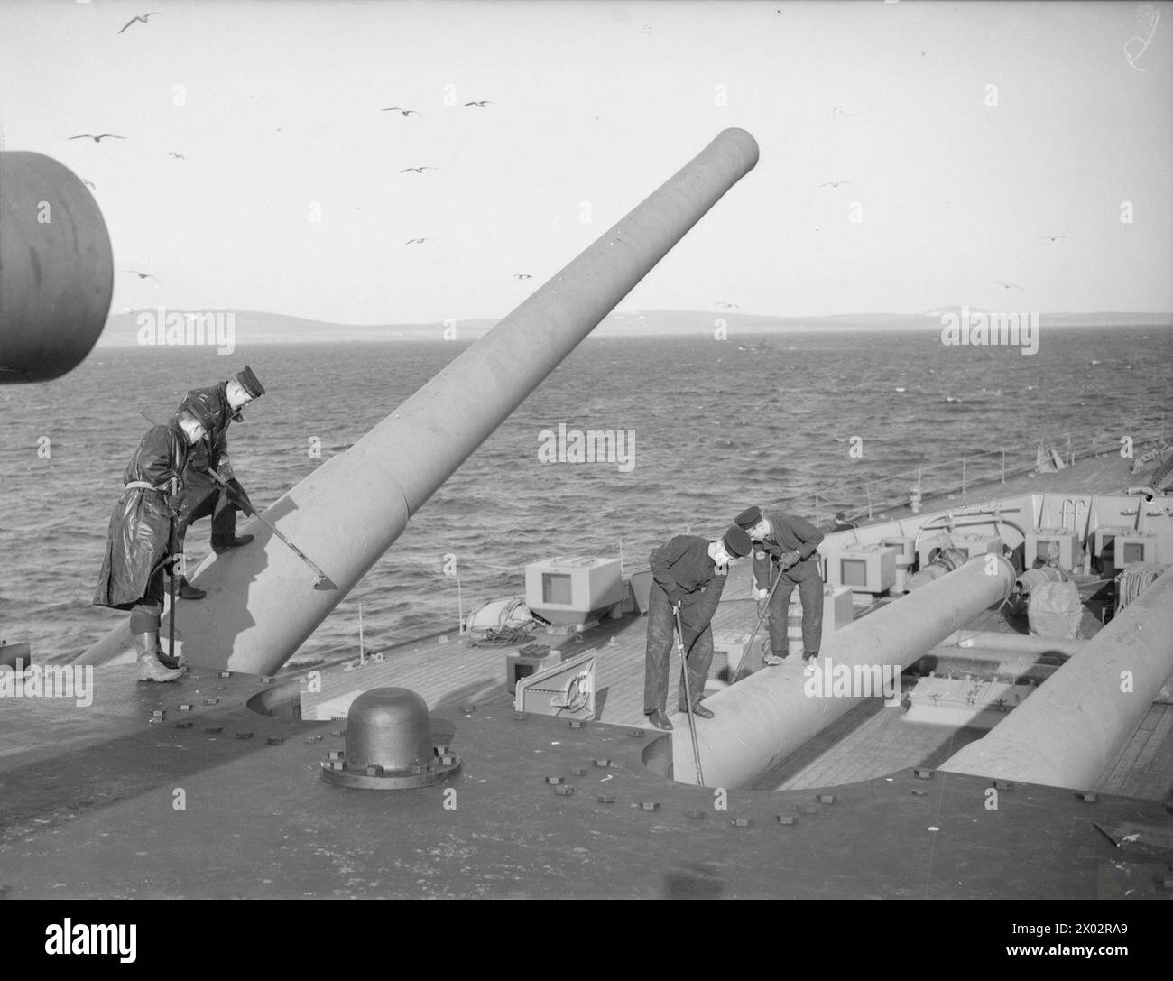 In 1941, aboard HMS King George V, the battleship's 14-inch turret is ...