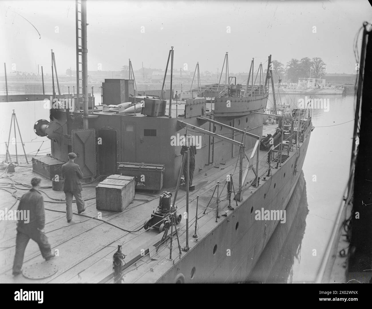 Men work on the after superstructure of a destroyer at Yarrow's naval ...