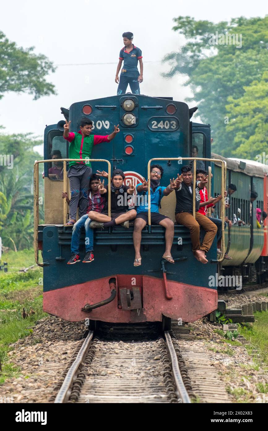 SYLHET, BANGLADESH - 14 APRIL, 2018: Young men sit on and one stands ...