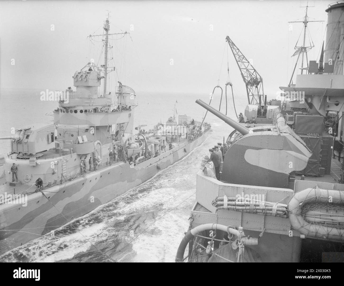 The cruiser HMS Norfolk refuels an American destroyer while on convoy ...