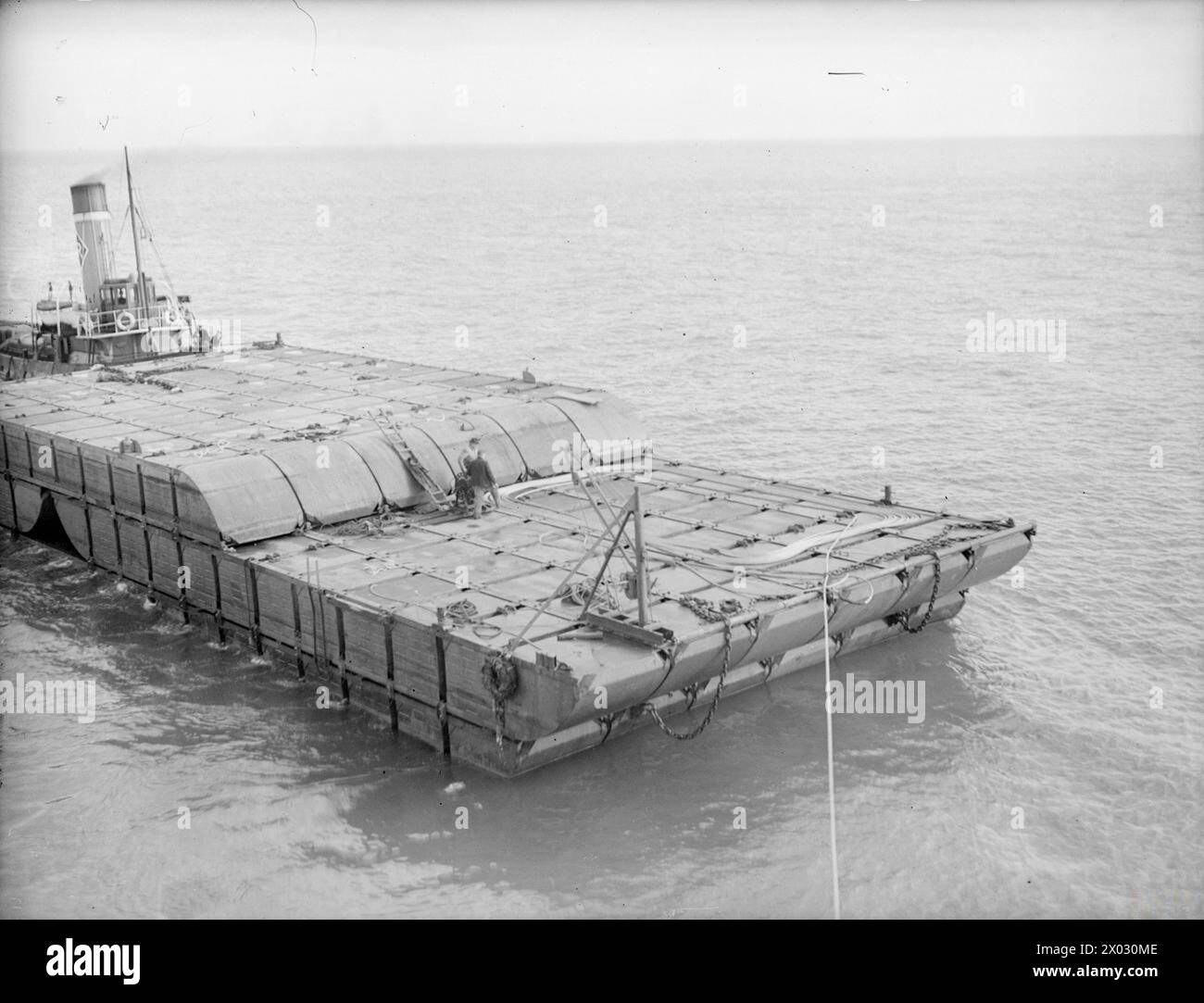 A British naval lighterage raft is towed by the motor vessel Glenapp ...