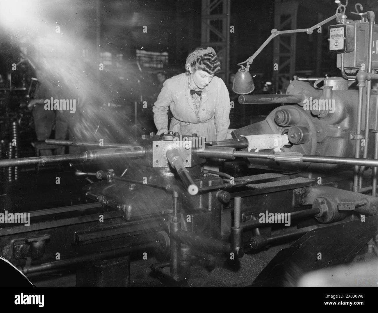 A woman operates a Capstan lathe to manufacture a component for a 17 ...