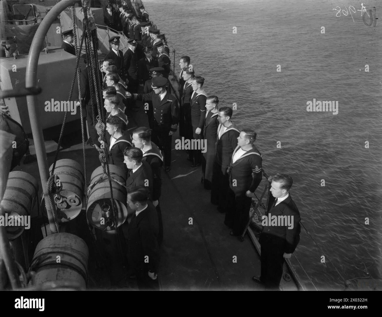 Commander J H Allison, DSO, RN, inspects divisions aboard HMS Kelvin, a ...