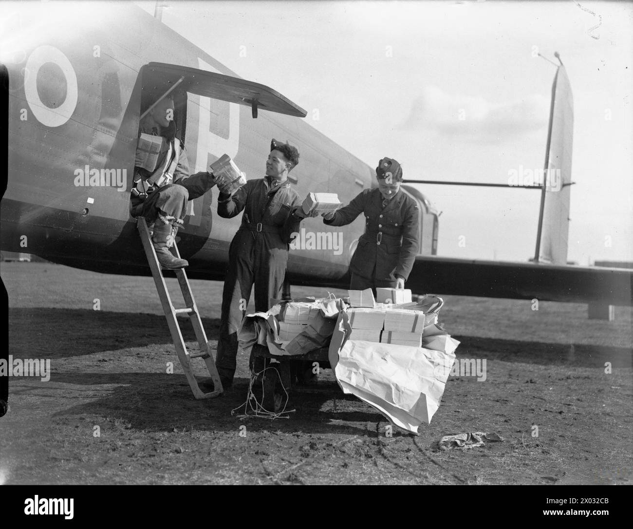 ROYAL AIR FORCE BOMBER COMMAND, 1939-1941. - Ground crewmen hand propaganda leaflets to a crew ...