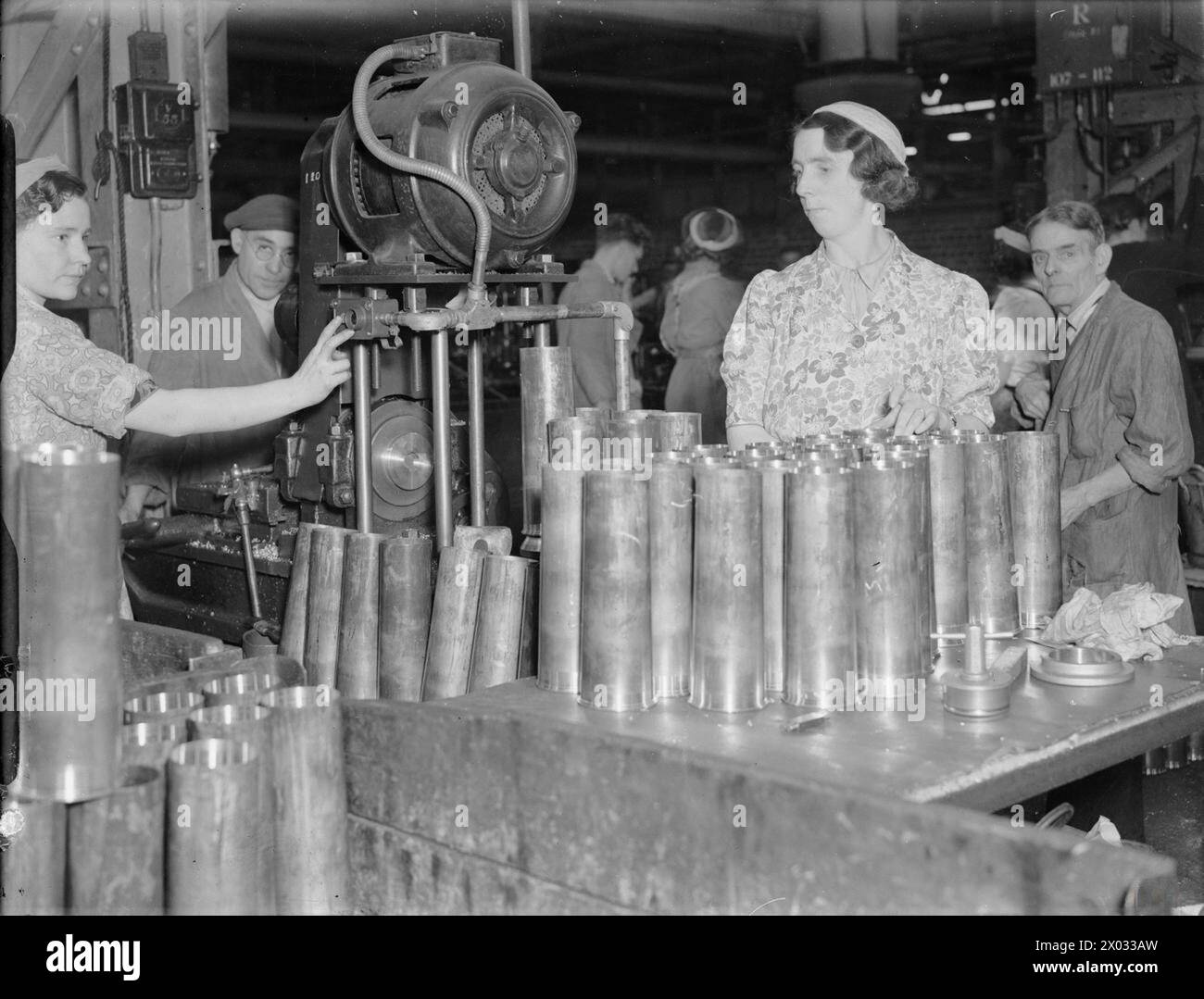 Factory workers in Britain operate a shell and cartridge case ...
