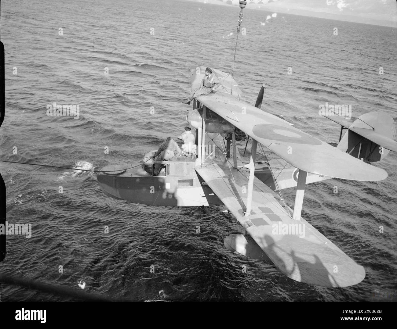 A Supermarine Walrus amphibious aircraft conducts a towed recovery ...