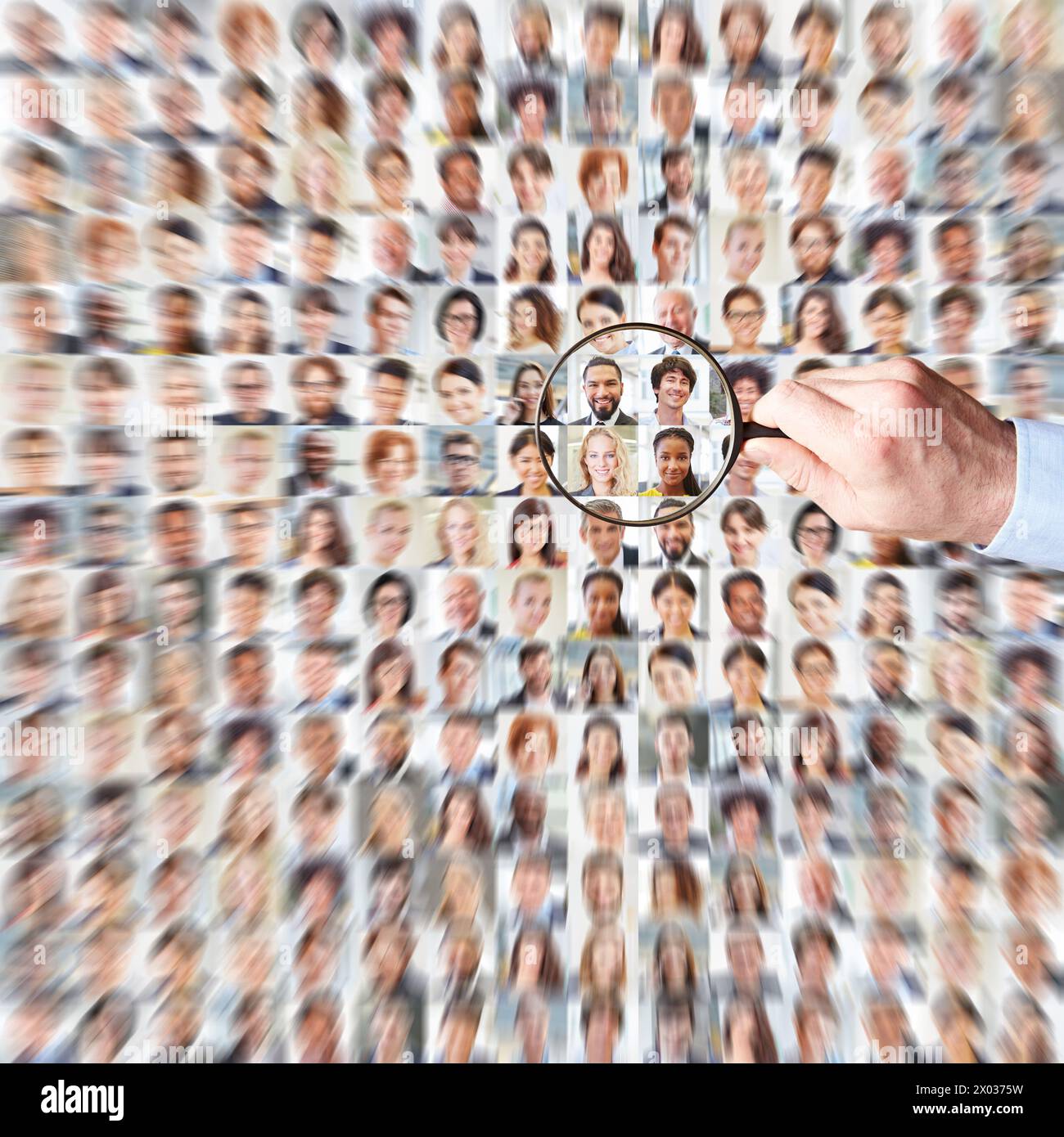 Portraits of business people are searched by hand with magnifying glass ...