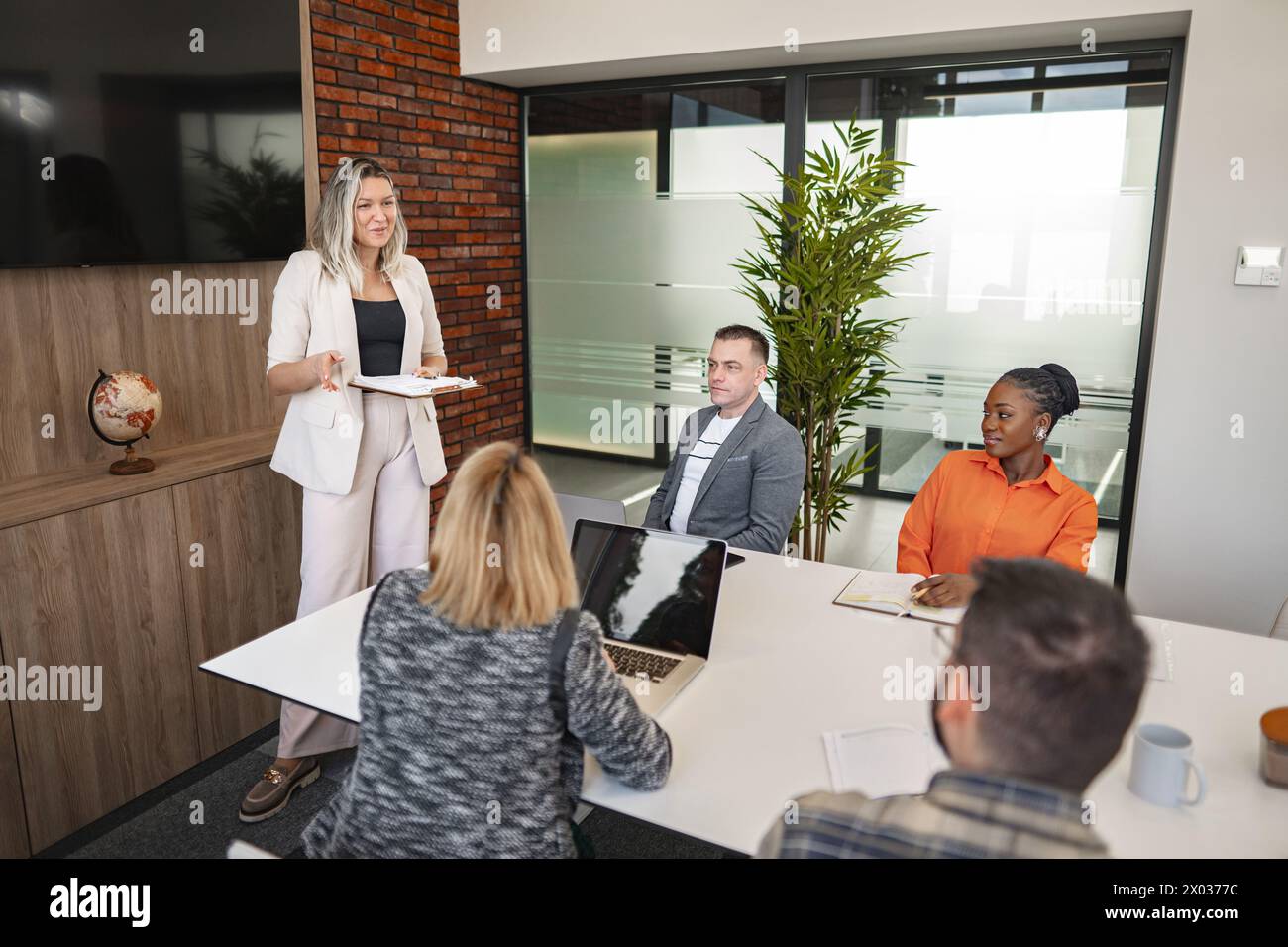 Woman Giving a Presentation to a Group of People Stock Photo - Alamy