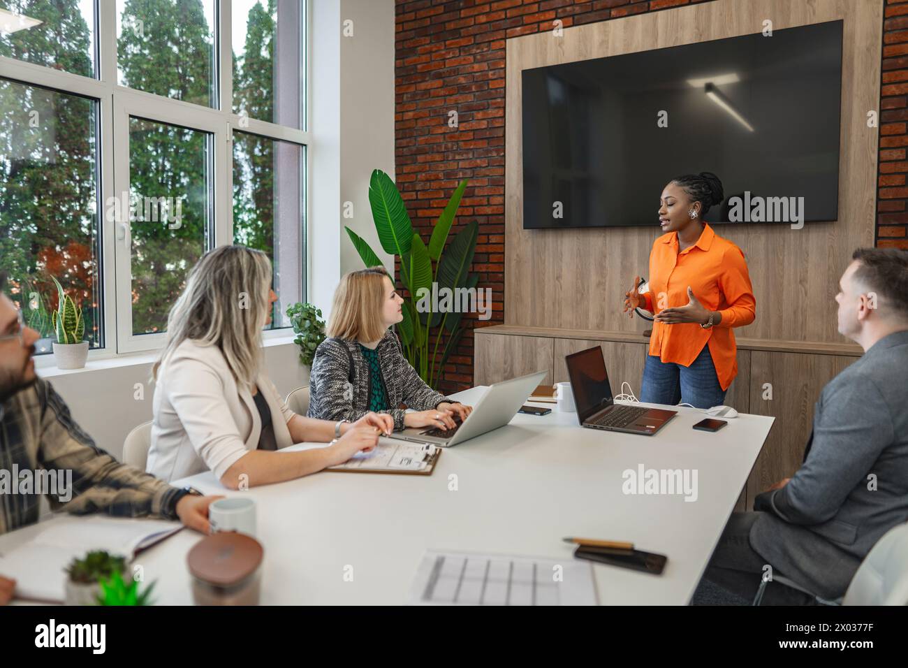Group of People Sitting Around Table With Laptops Stock Photo - Alamy