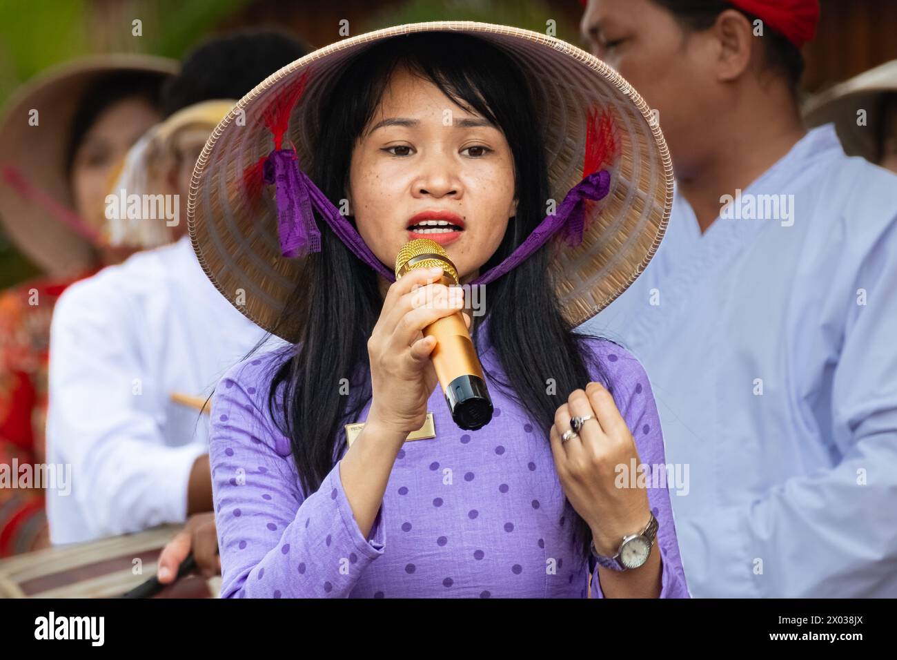 Beautiful Vietnamese woman performing with a microphone on traditional ...