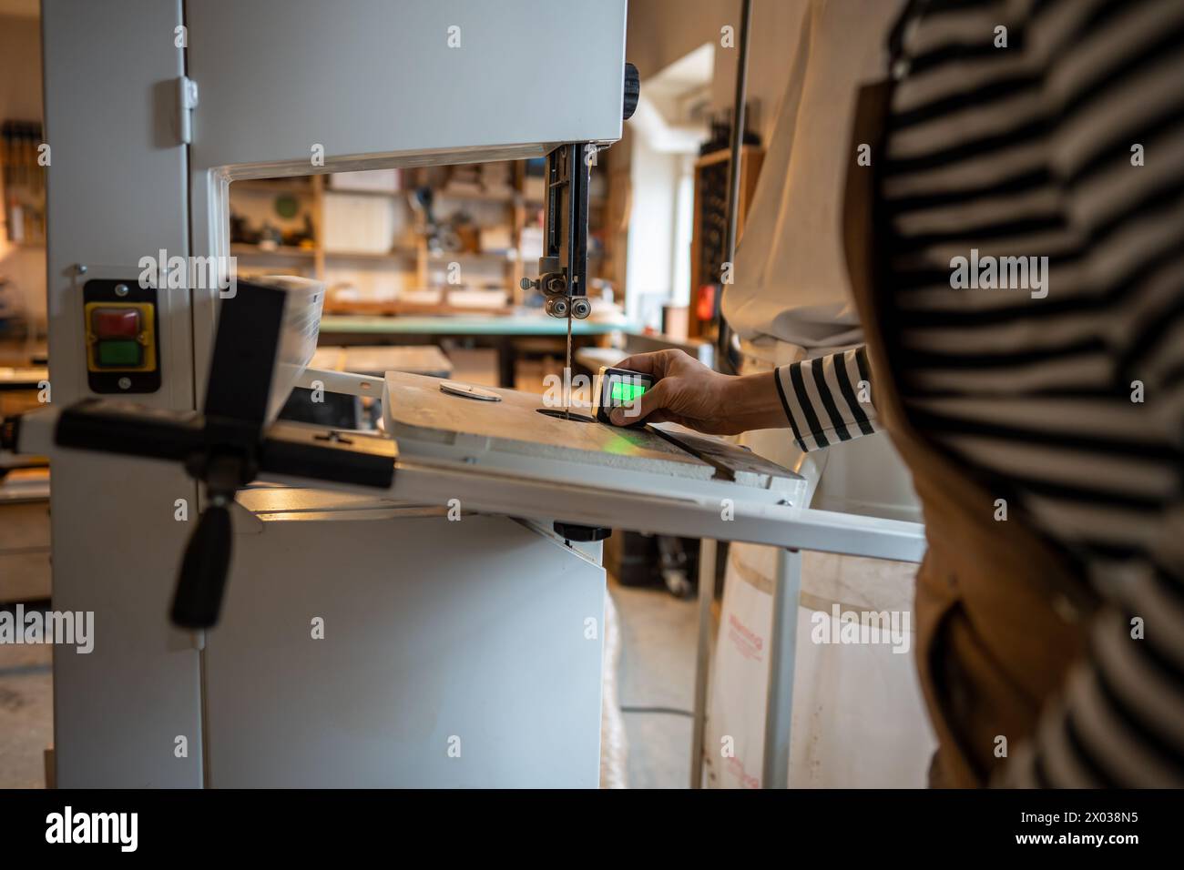 Male carpenter holding digital magnetic inclinometer with level, adjust ...