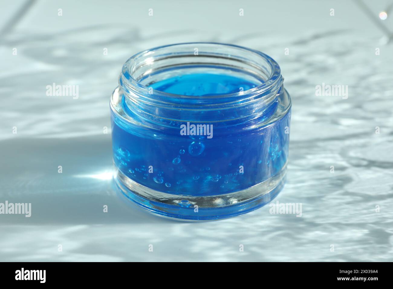 Open jar of cosmetic product on light blue background Stock Photo - Alamy
