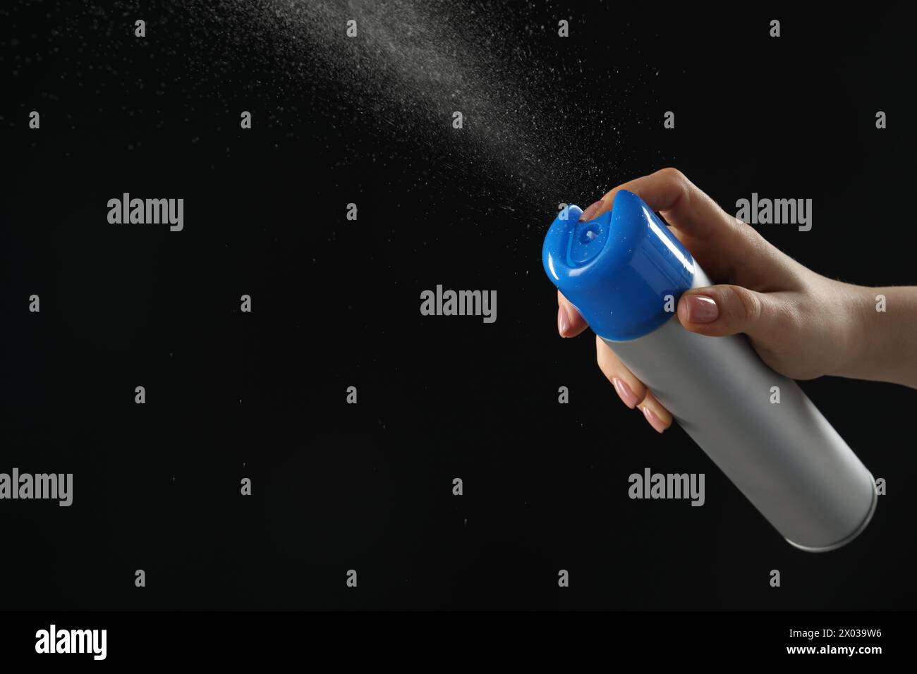 Woman spraying air freshener on black background, closeup. Space for ...