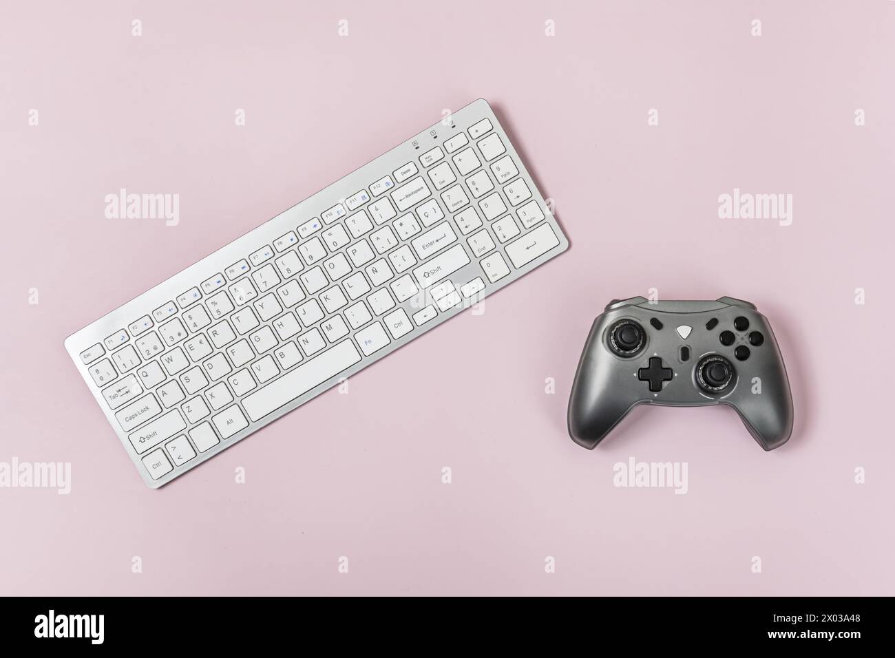 PC keyboard and gamepad on a smooth pink surface Stock Photo - Alamy