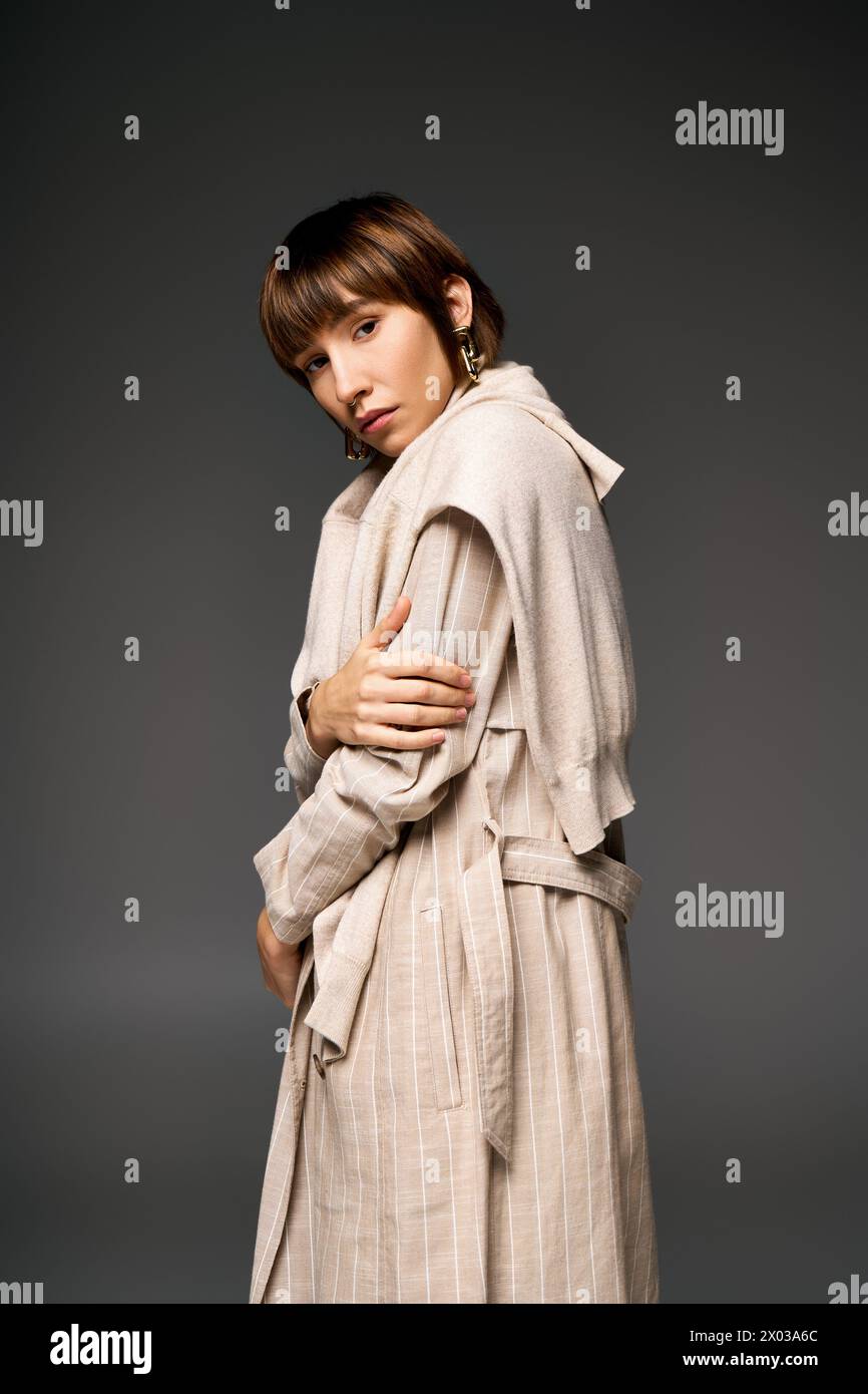 A stylish young woman with short hair striking a pose while wearing a ...