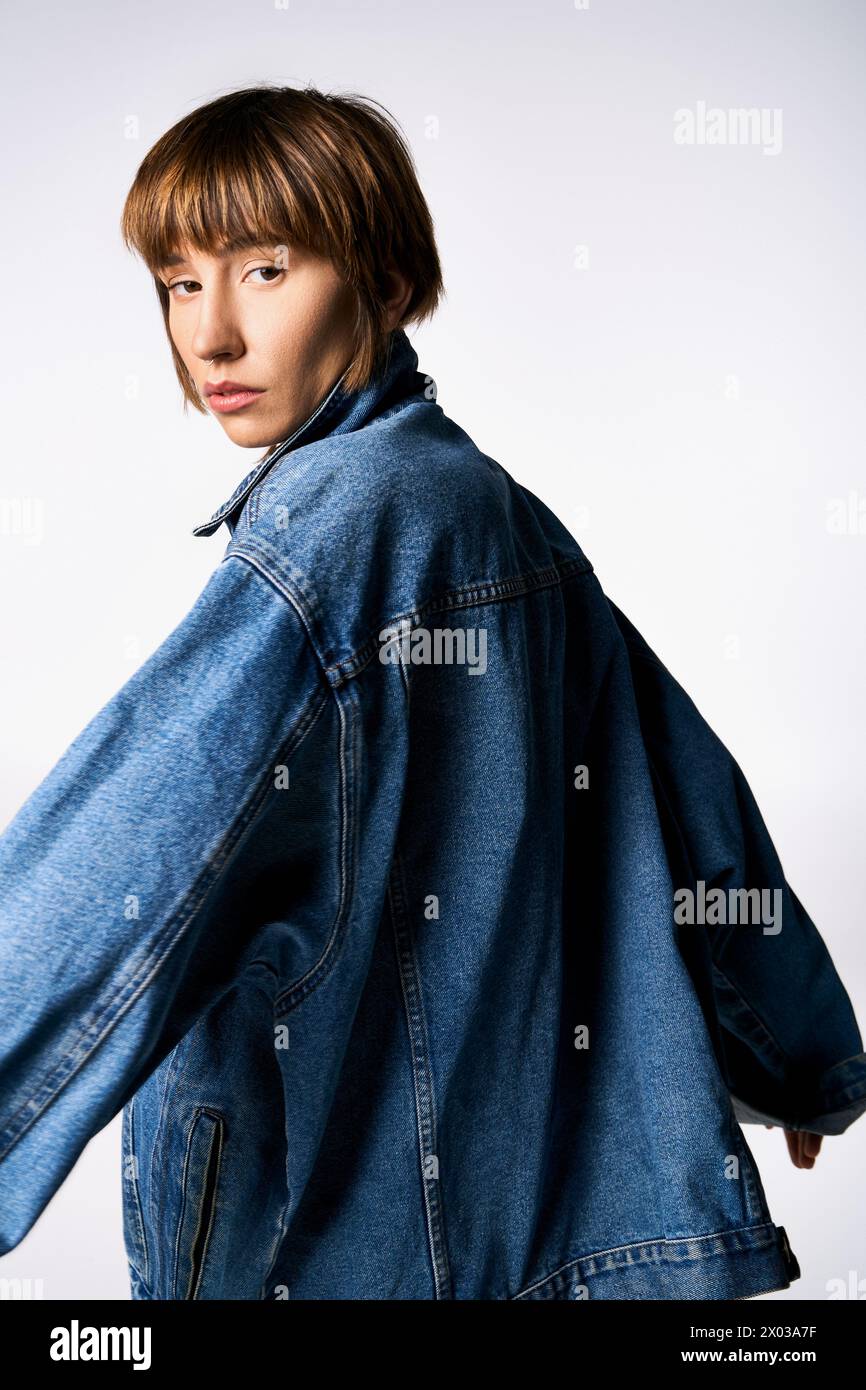 A fashionable young woman wearing a denim jacket poses confidently for ...