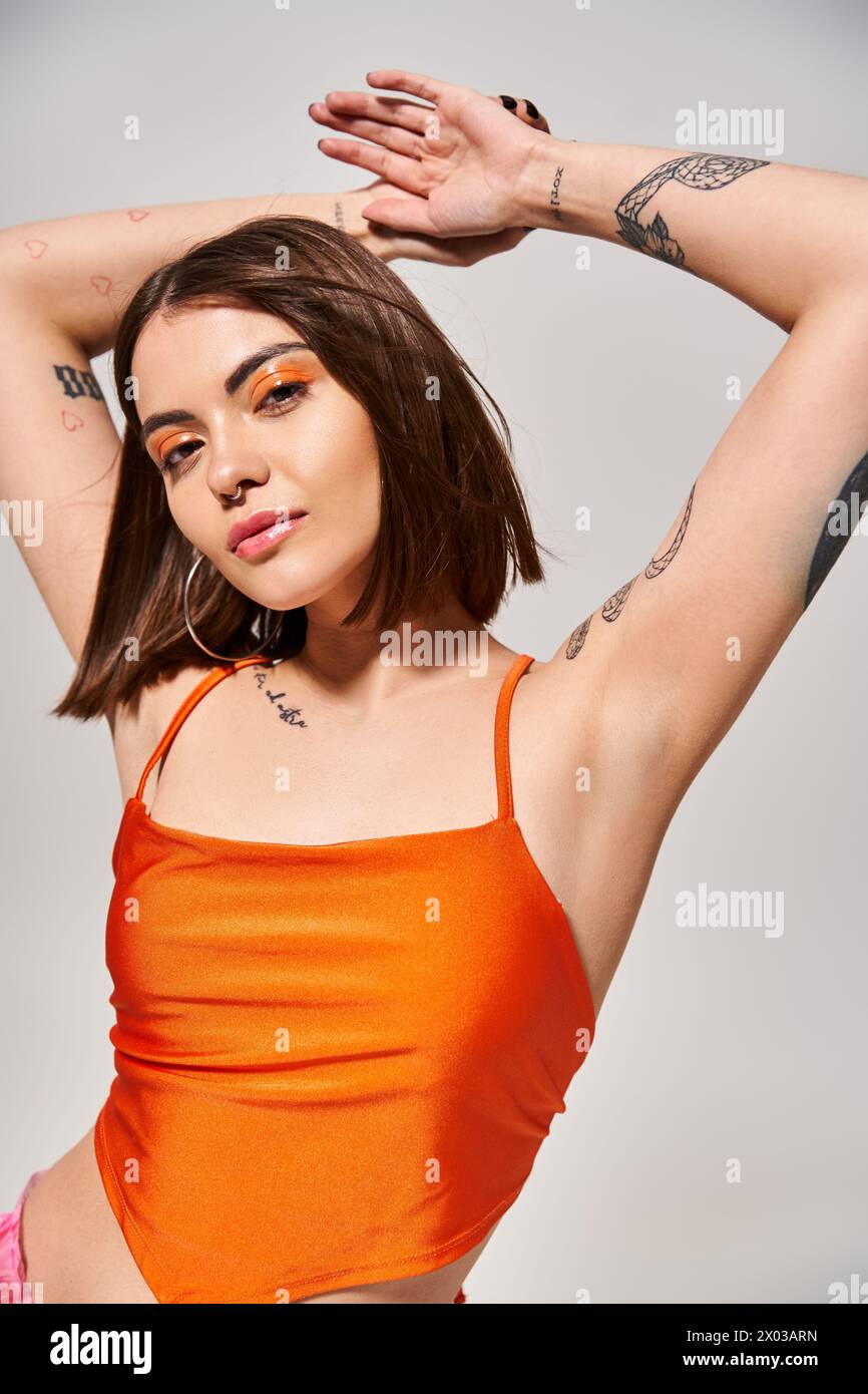 A young woman with brunette hair showcases intricate tattoos on her ...