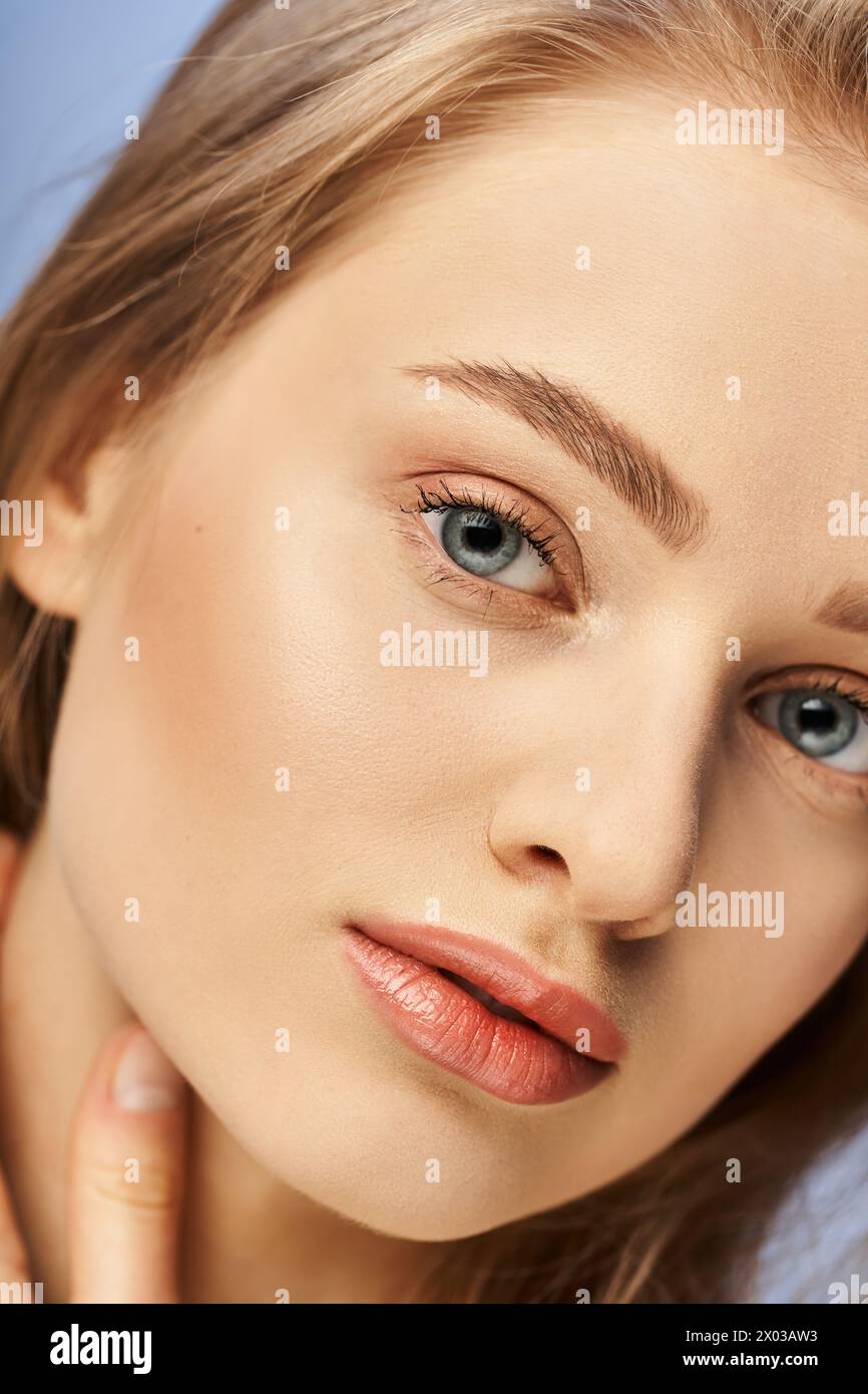 A young blonde woman with striking blue eyes, up close and captivating ...