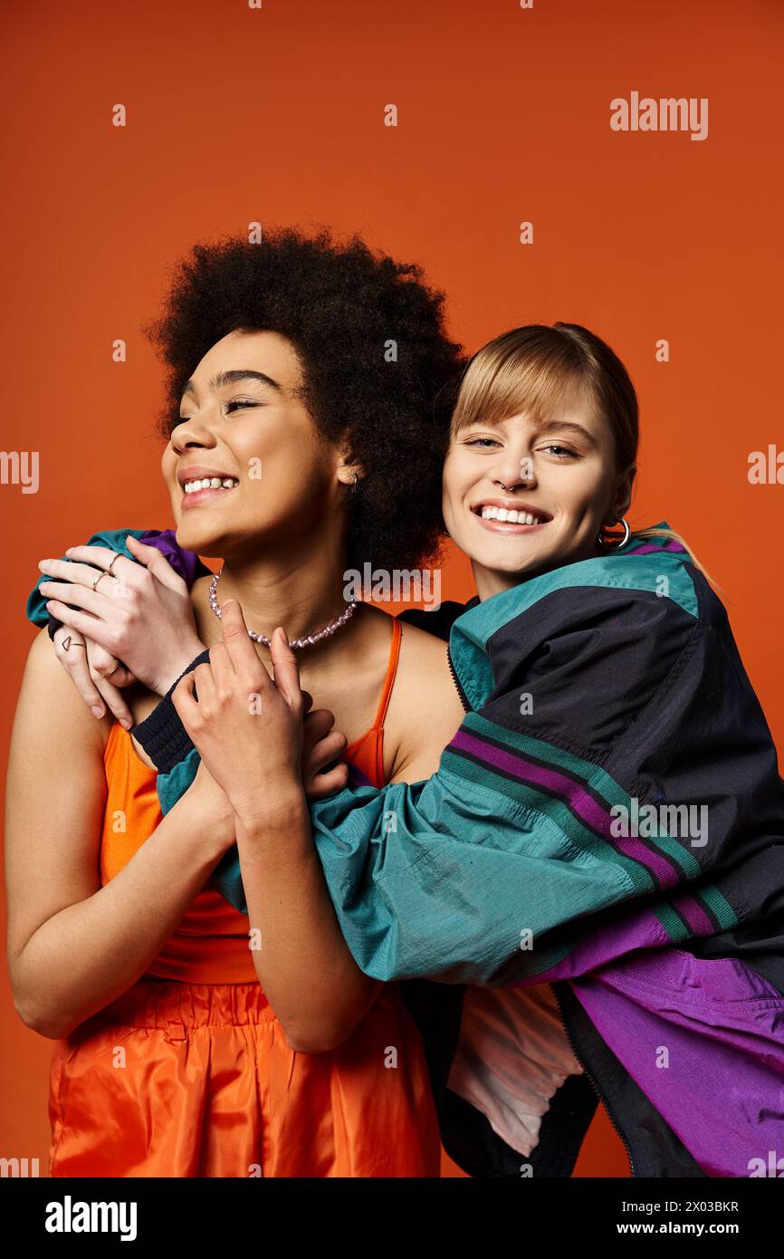 Two women, of different ethnicities, close in a warm hug, smiles ...