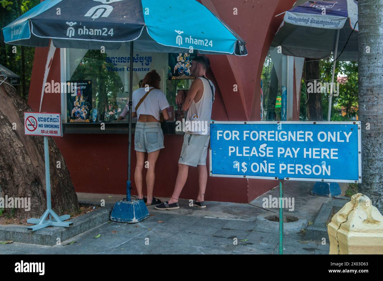 A young white couple pay their fee at the ticket booth near the "For ...