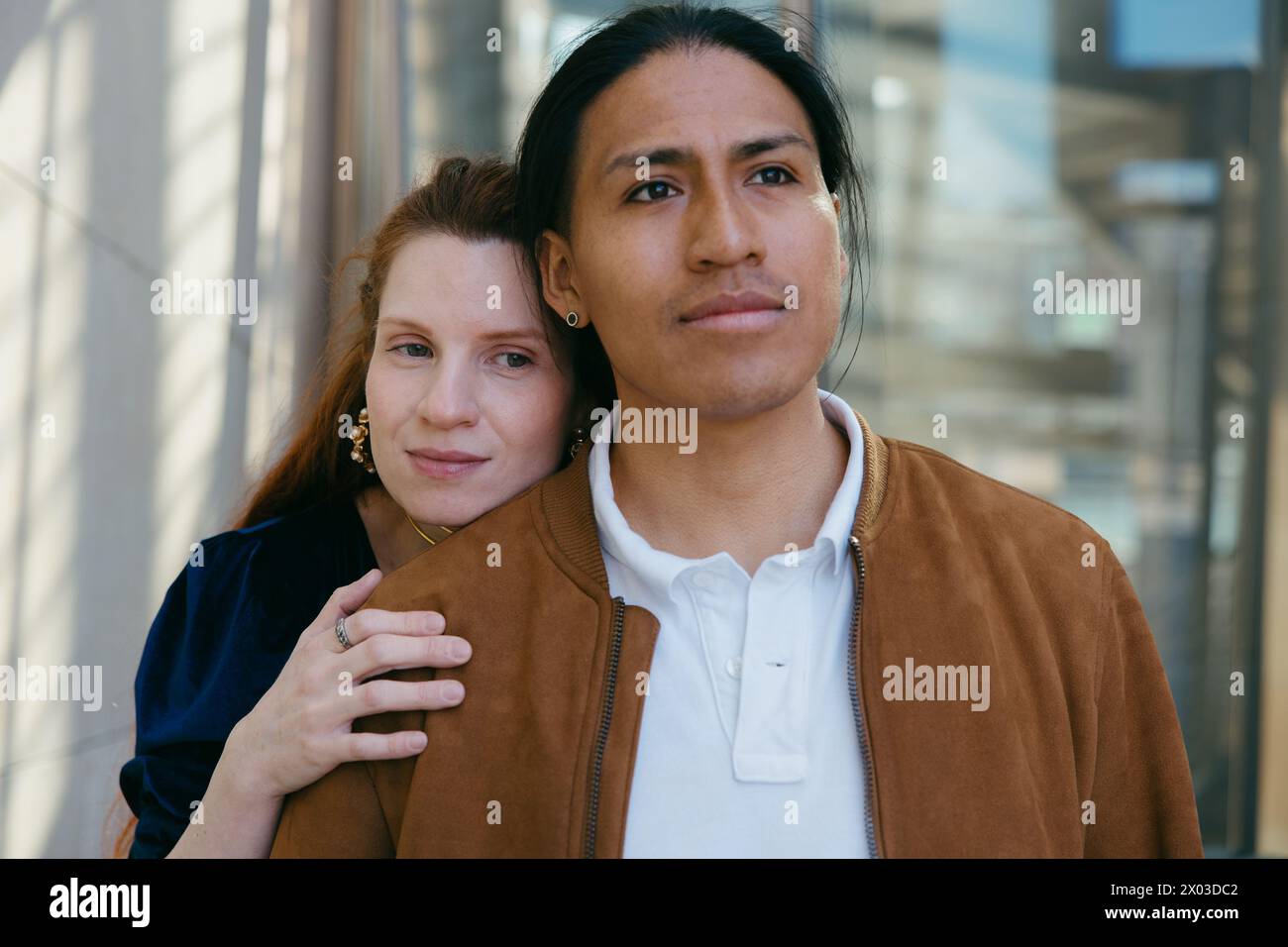 A young, relaxed couple enjoys a warm, intimate moment while exploring ...