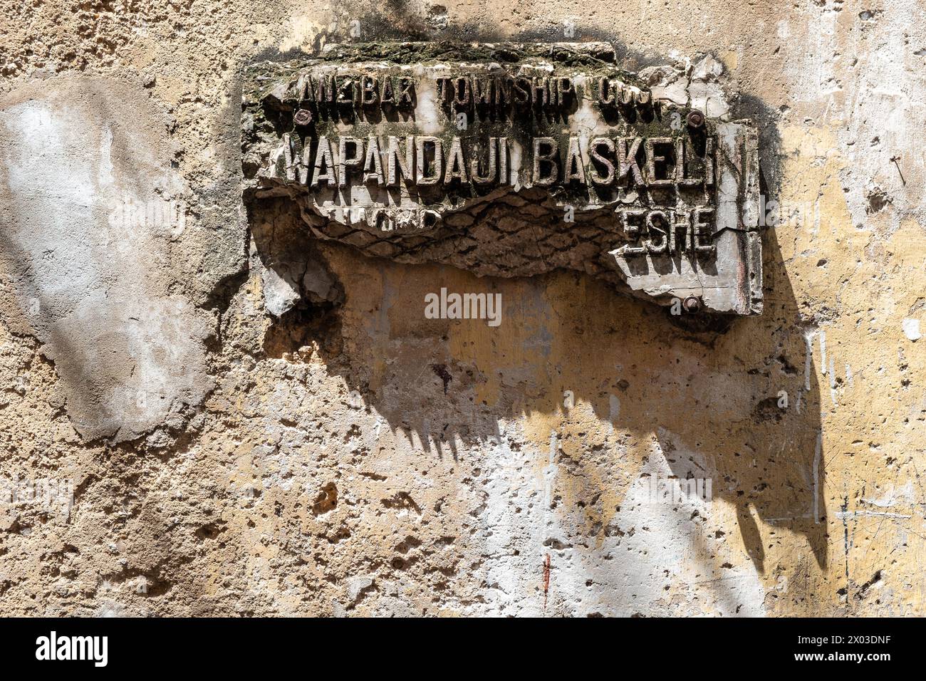 ZANZIBAR, TANZANIA - 13 DECEMBER, 2018: A crumbled concrete street sign ...