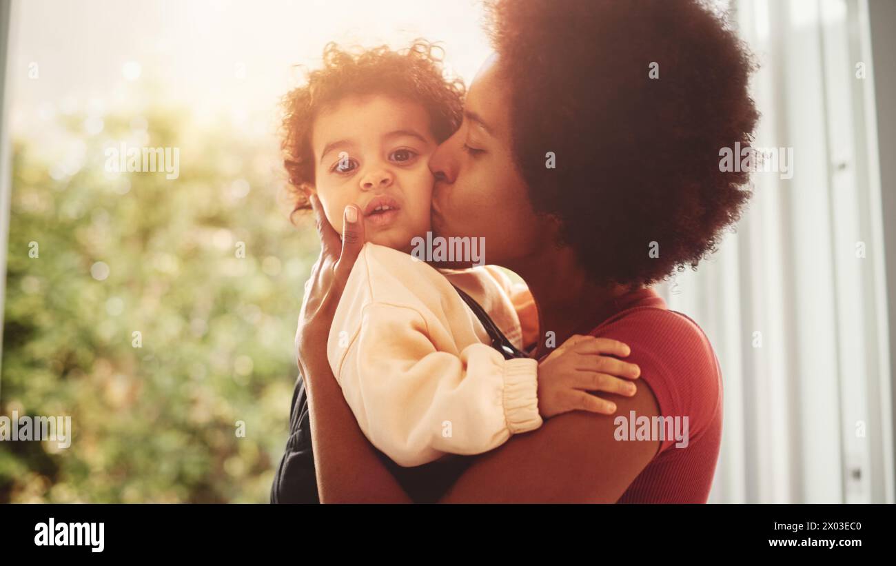 Loving Mother Hugging and Holding Adorable Baby Boy at Modern Home ...