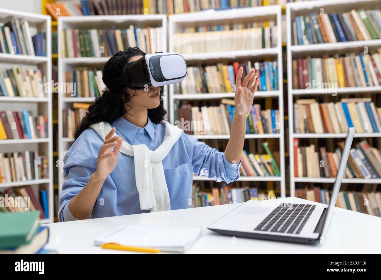Young woman wears virtual reality headset in library, experiencing immersive technology with ...