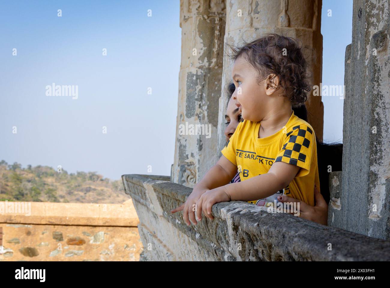 innocent kid with mother at window at morning from flat angle Stock ...