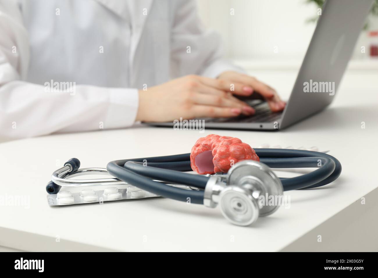 Endocrinologist working at table, focus on stethoscope and model of ...