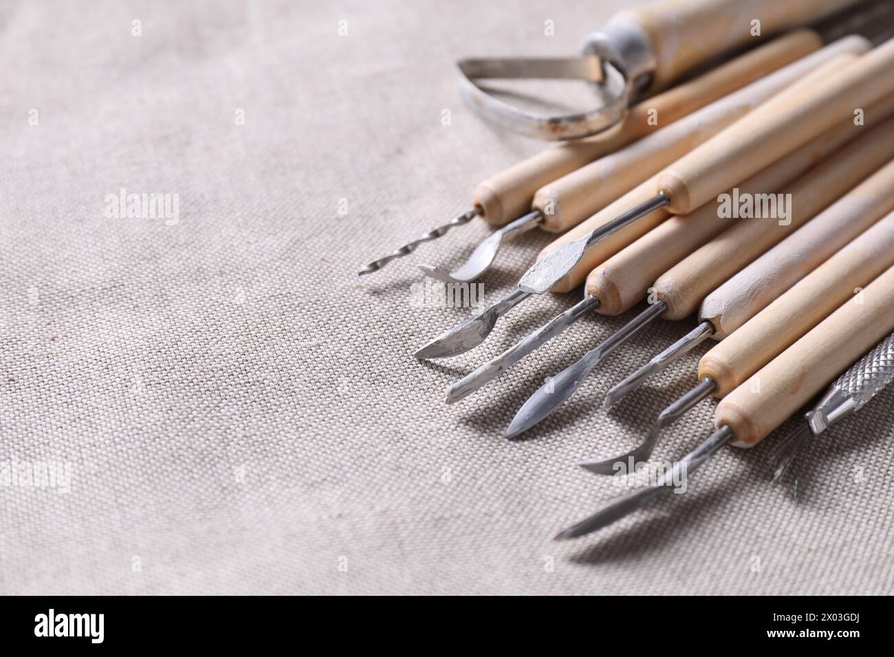 Set of different clay crafting tools on grey fabric, closeup. Space for ...