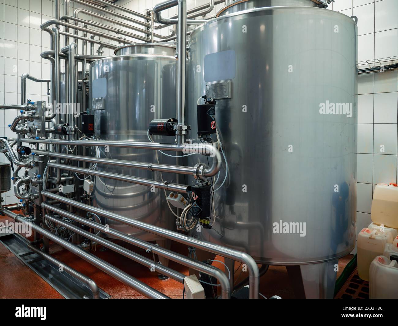 Modern brewery setup with large stainless steel fermentation tanks ...