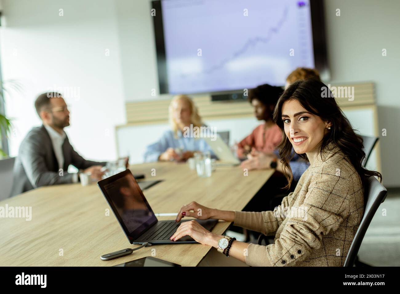 Confident businesswoman engages in a meeting, her smile reflecting ...