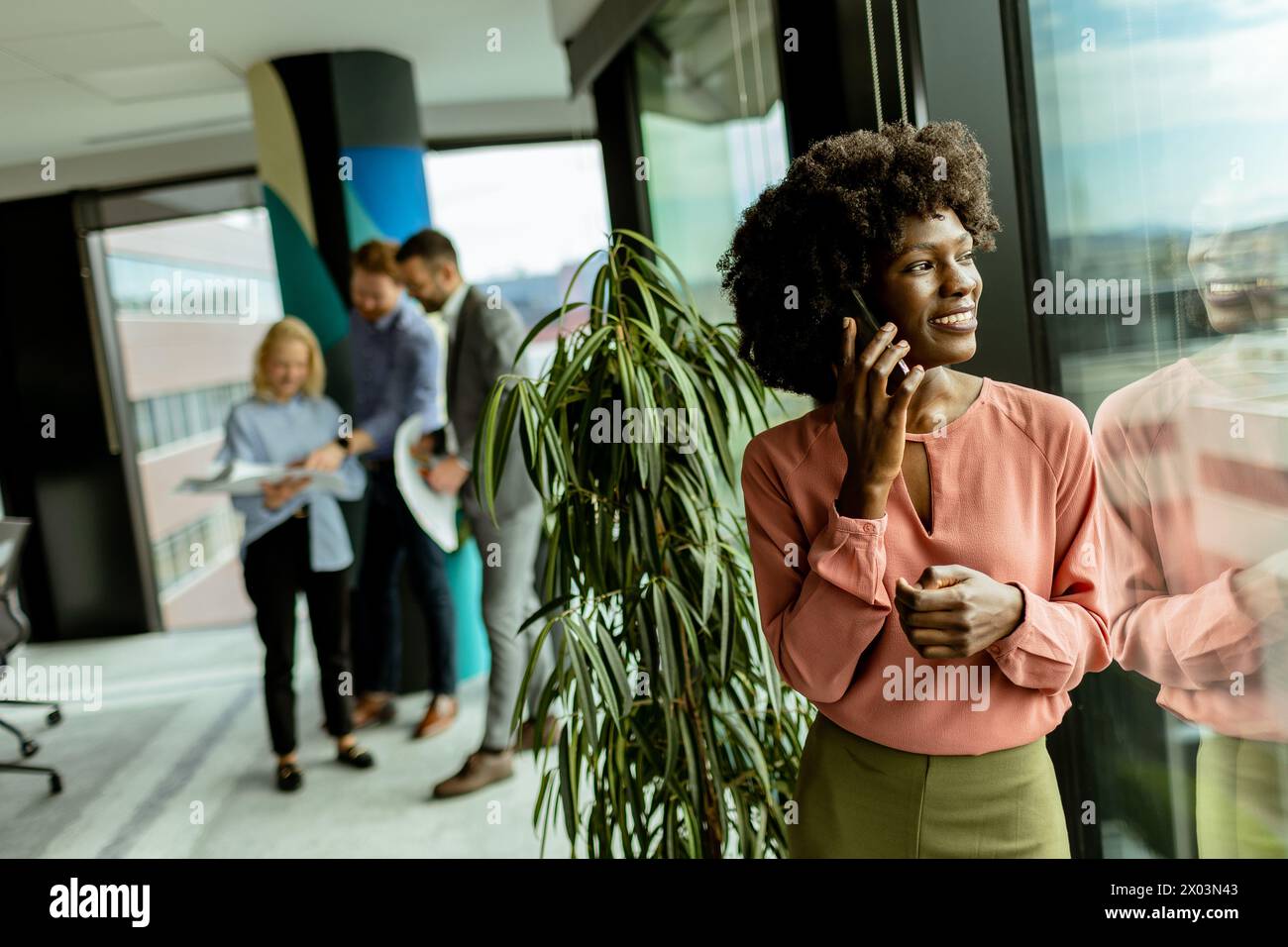 African American woman smiles while talking on the phone amidst ...