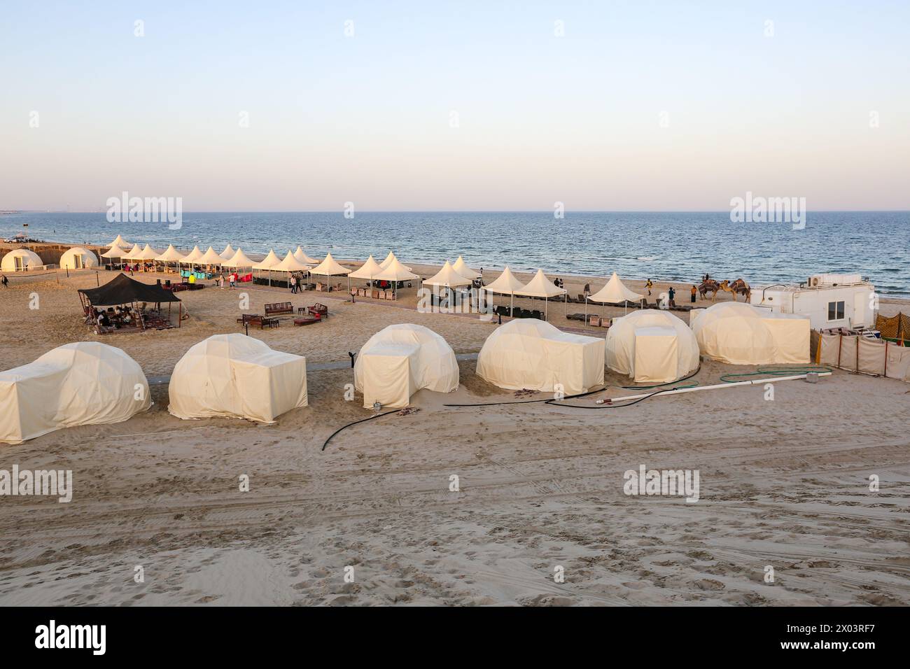 Tents at QIA desert camp at Inland Sea in Persian Gulf at sunset sky ...