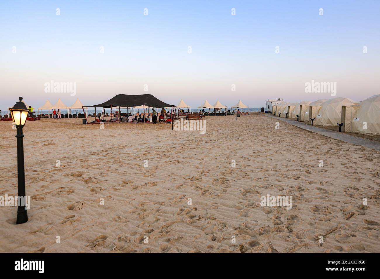 Tents at QIA desert camp at Inland Sea in Persian Gulf at sunset sky ...