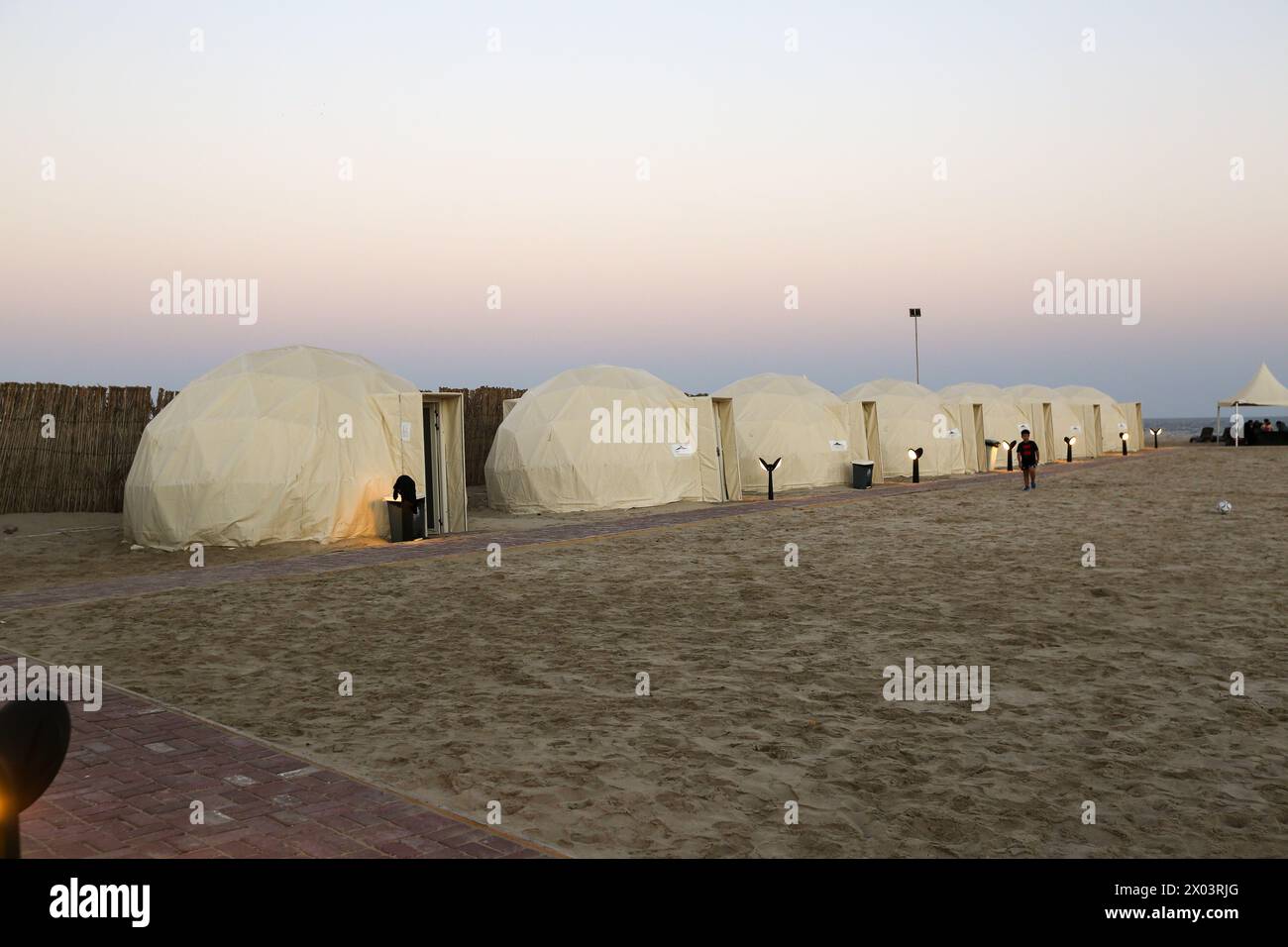 Tents at QIA desert camp at Inland Sea in Persian Gulf at sunset sky ...