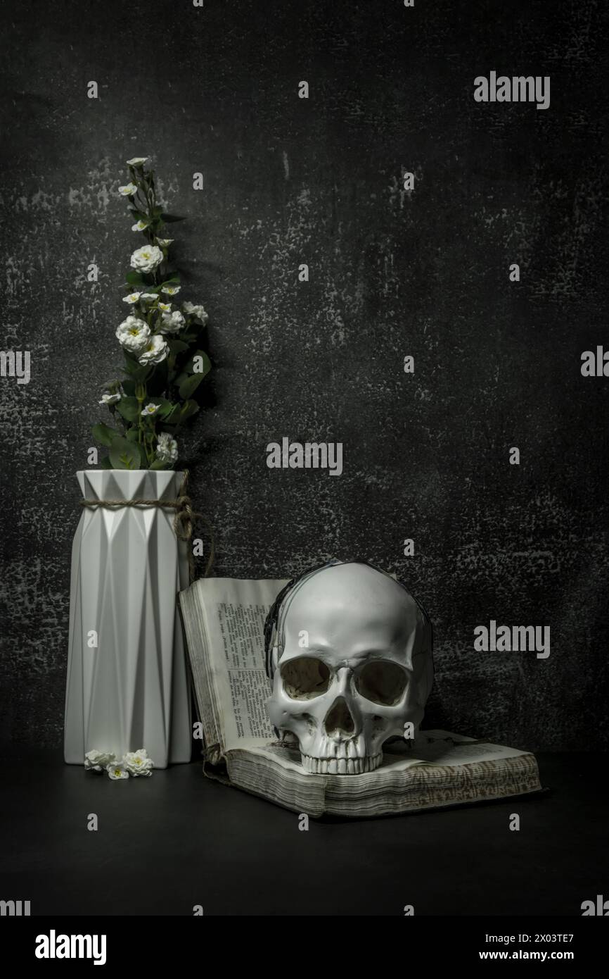 A spooky still life with a white skull on an open book Stock Photo - Alamy