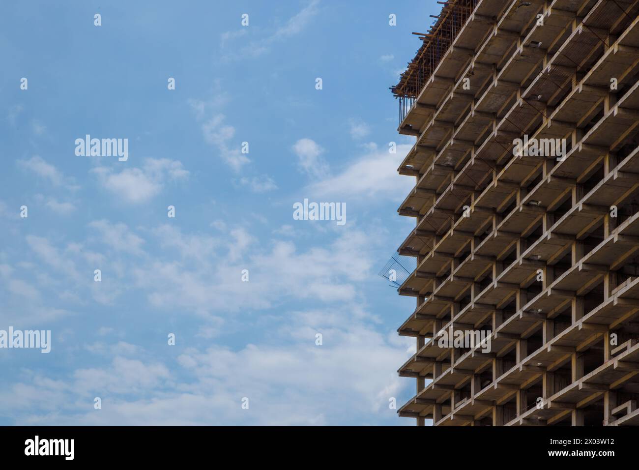High-rise apartment building under construction against a blue sky with ...