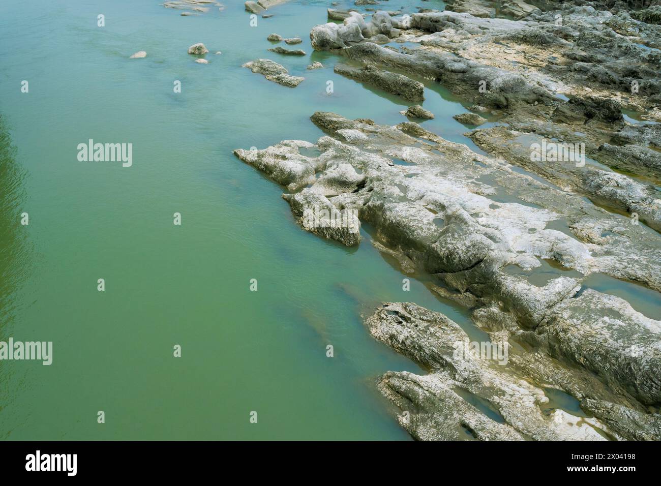 Mountain river and rocky coast. Green, muddy water in the river ...