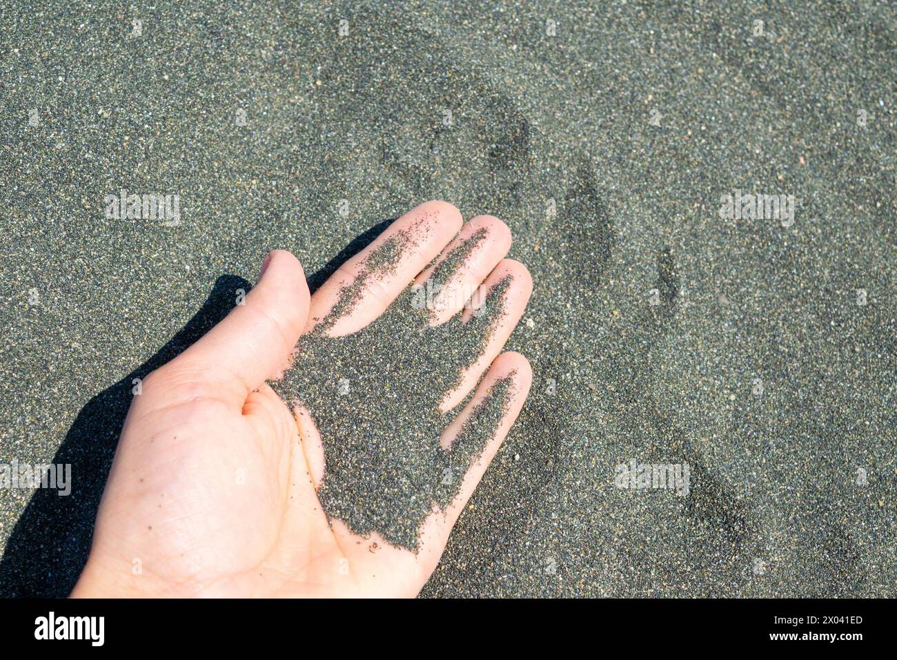 Black magnetic sands. Natural backgrounds and textures. Sand in hand ...