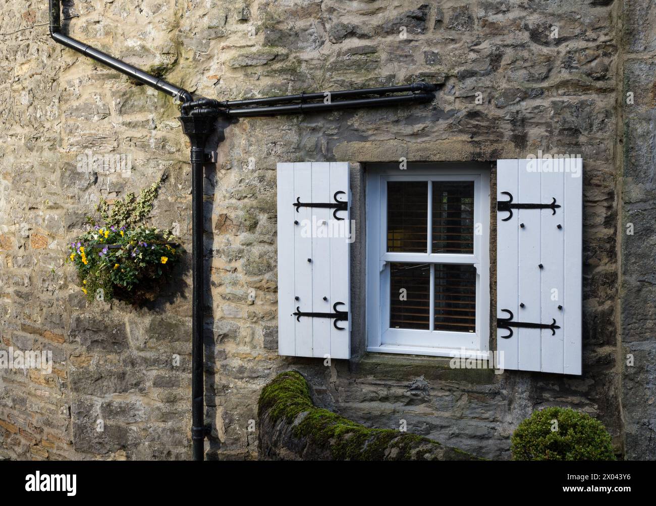 Window with open wooden shutters and hanging basket on a building in ...