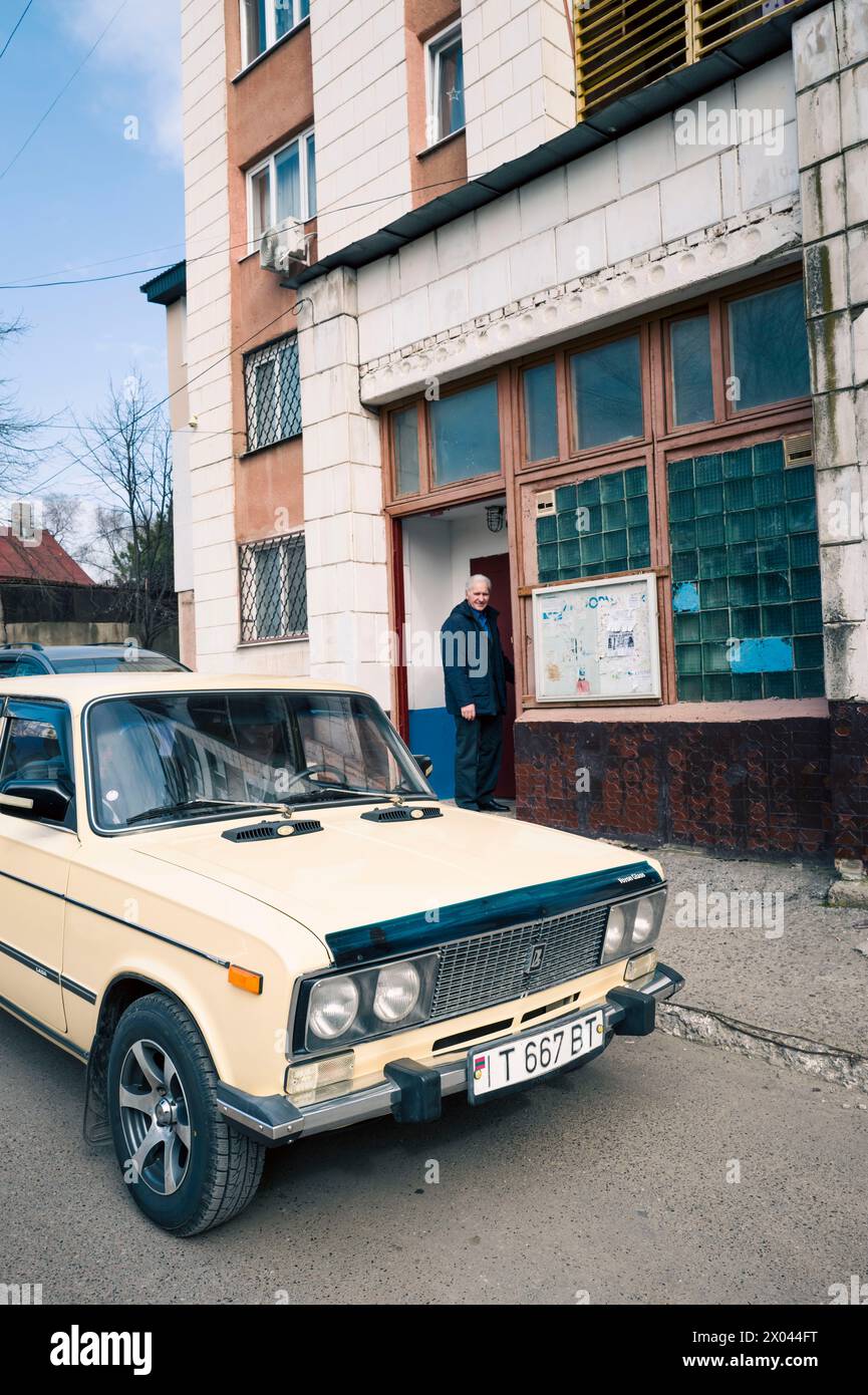A car with its driver at the wheel waiting in front of a building ...