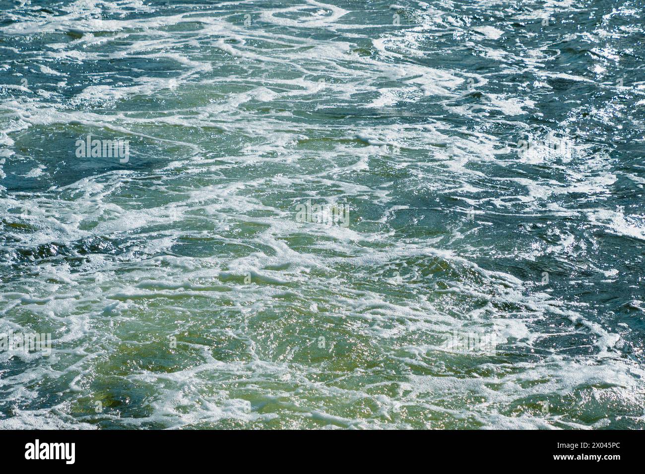 Foaming, disturbed water after a boat has passed. Water background ...