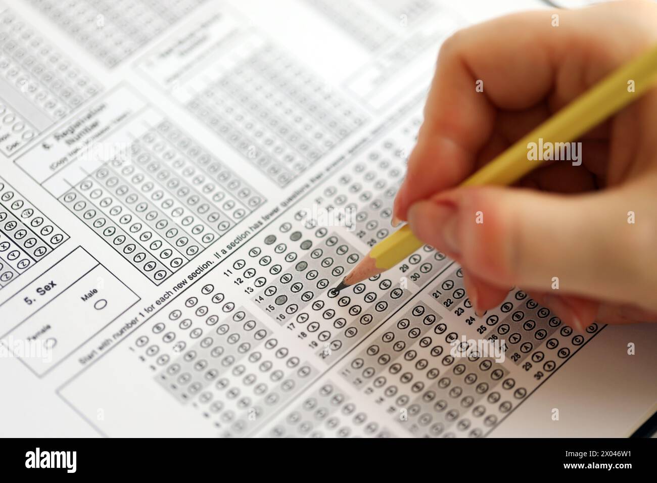 Female student hands testing in exercise and taking fill in exam paper ...