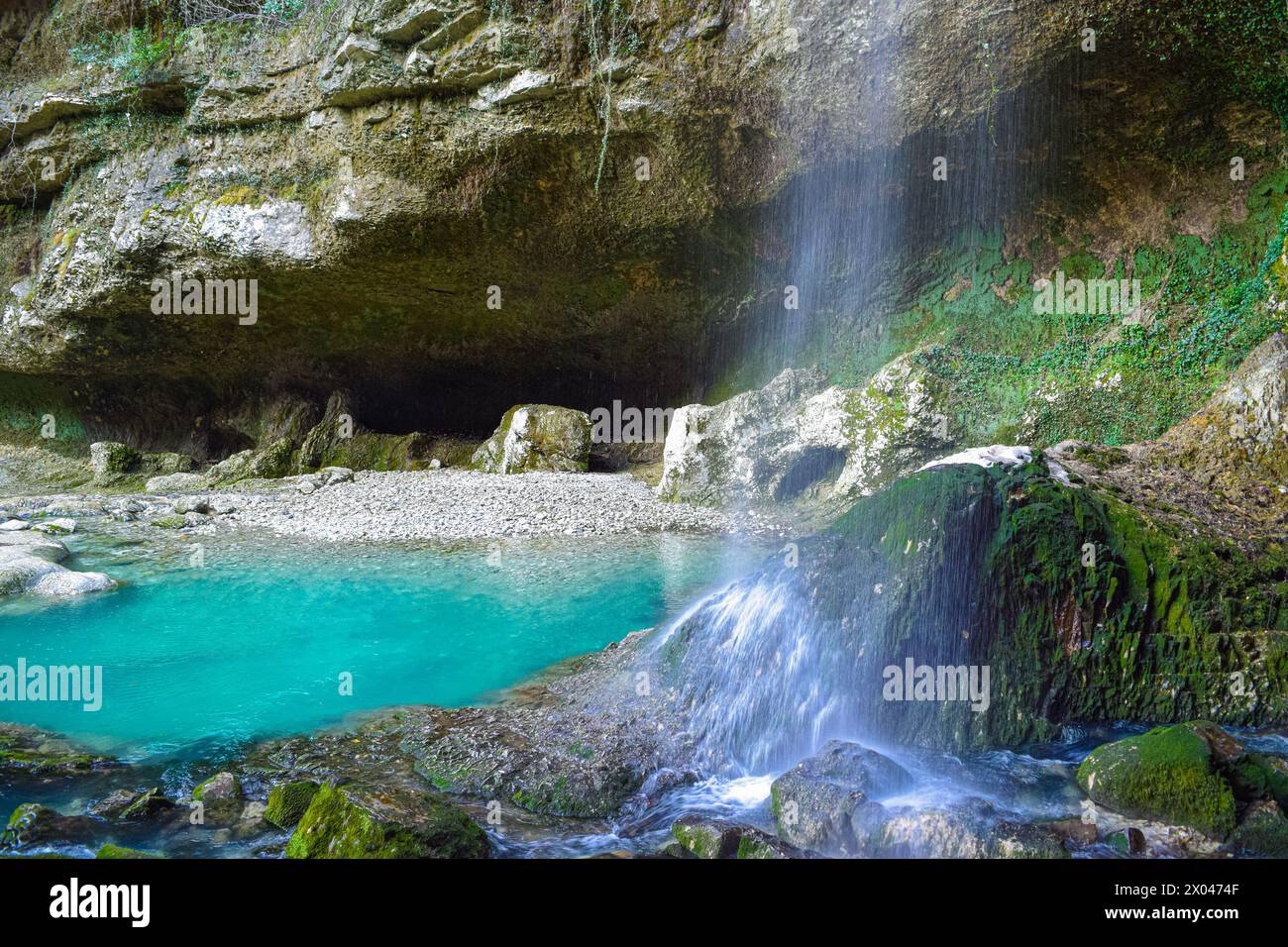 Waterfall in a gorge among the rocks. Beautiful natural landscape. Blue ...