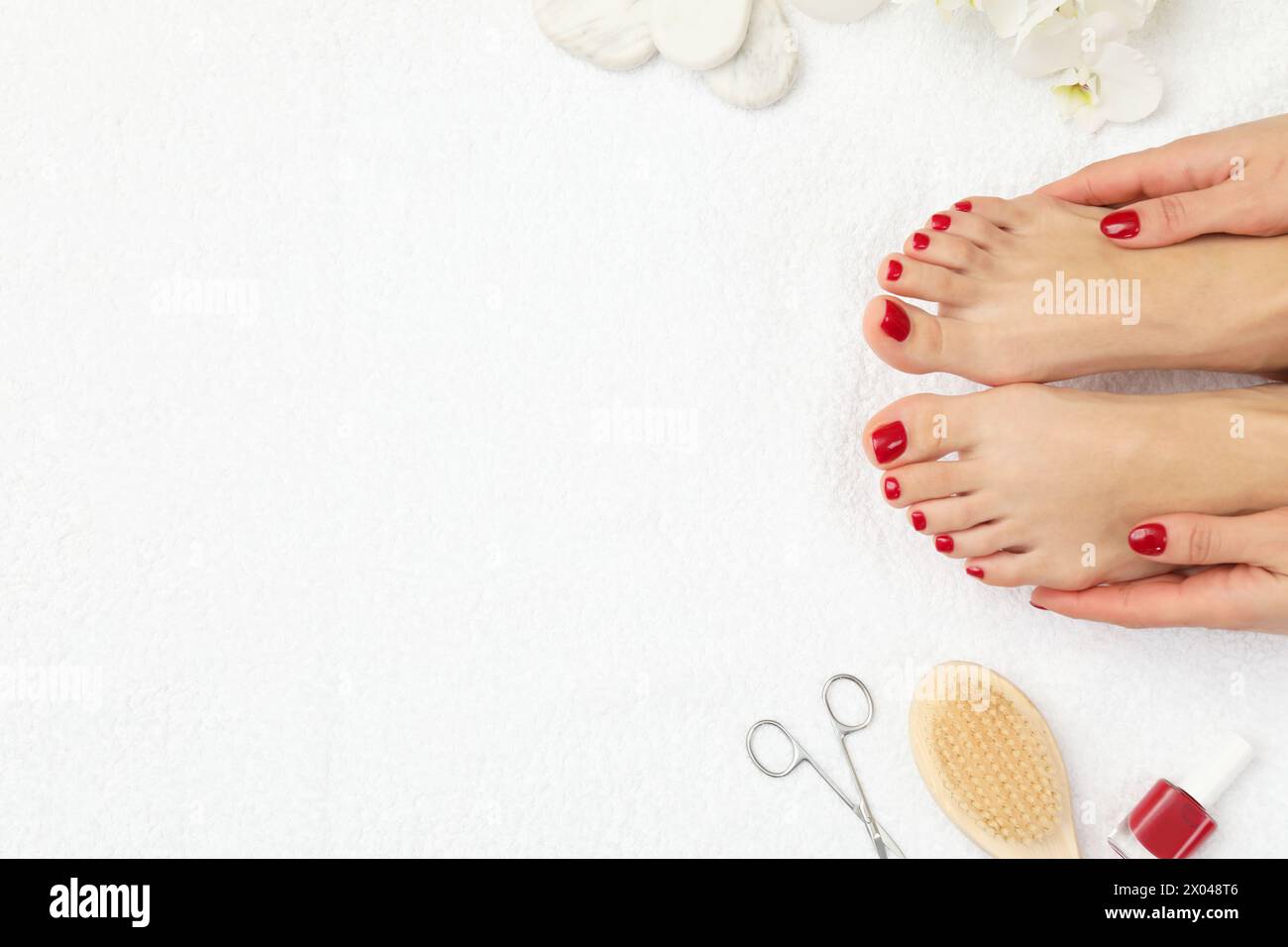 Woman with stylish red toenails after pedicure procedure and orchid ...