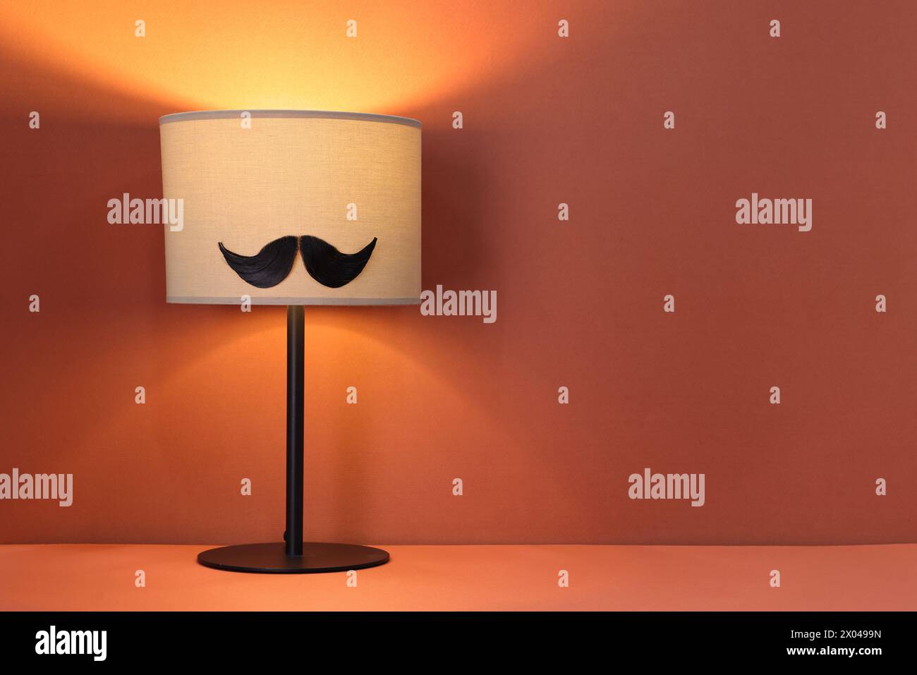 Man's face made of artificial mustache and lamp on terracotta ...