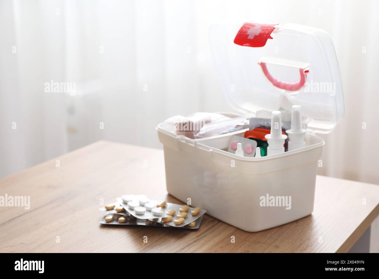 First aid kit and medicaments on wooden table indoors, closeup. Space ...