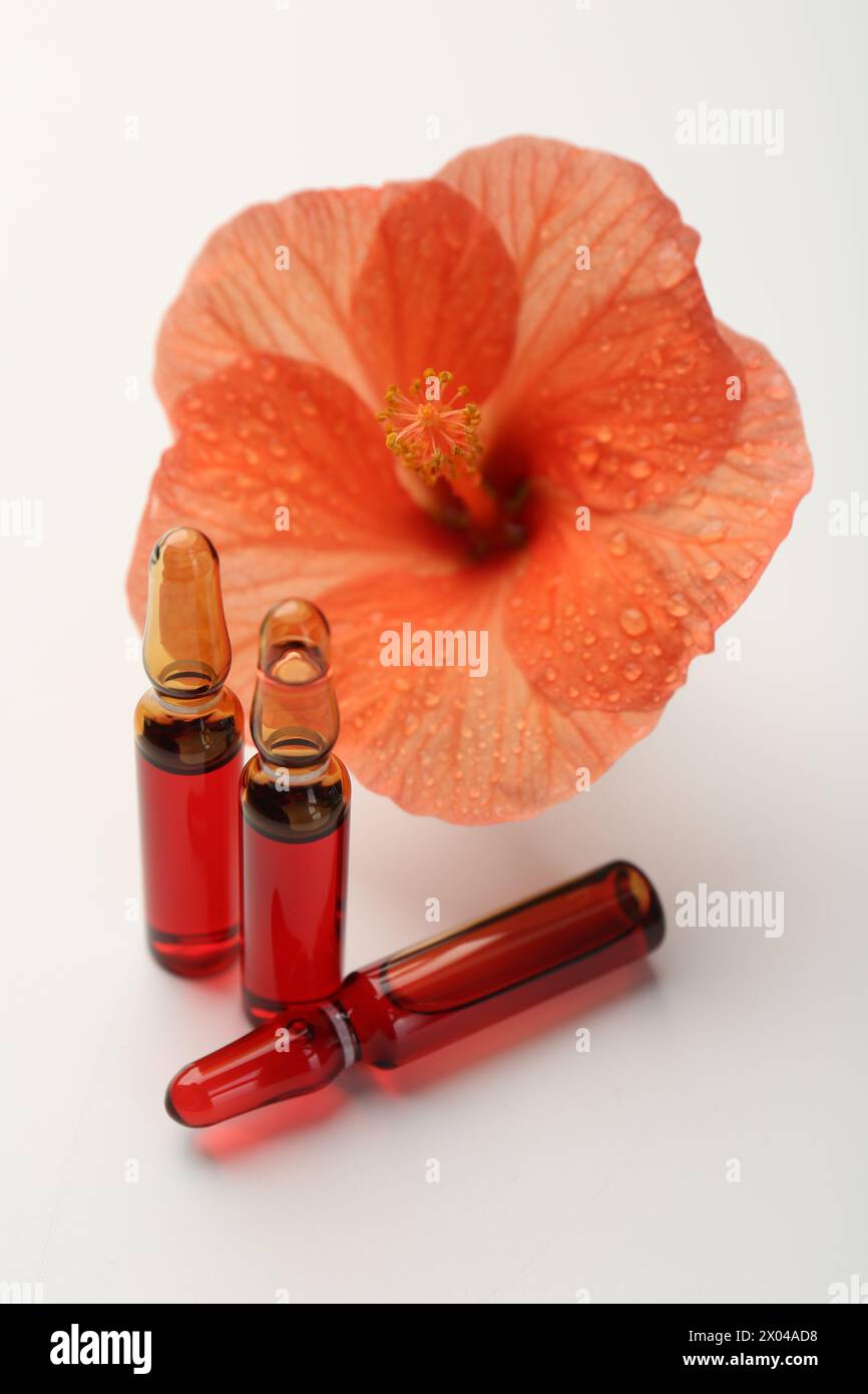 Skincare ampoules and hibiscus flower on white background Stock Photo ...